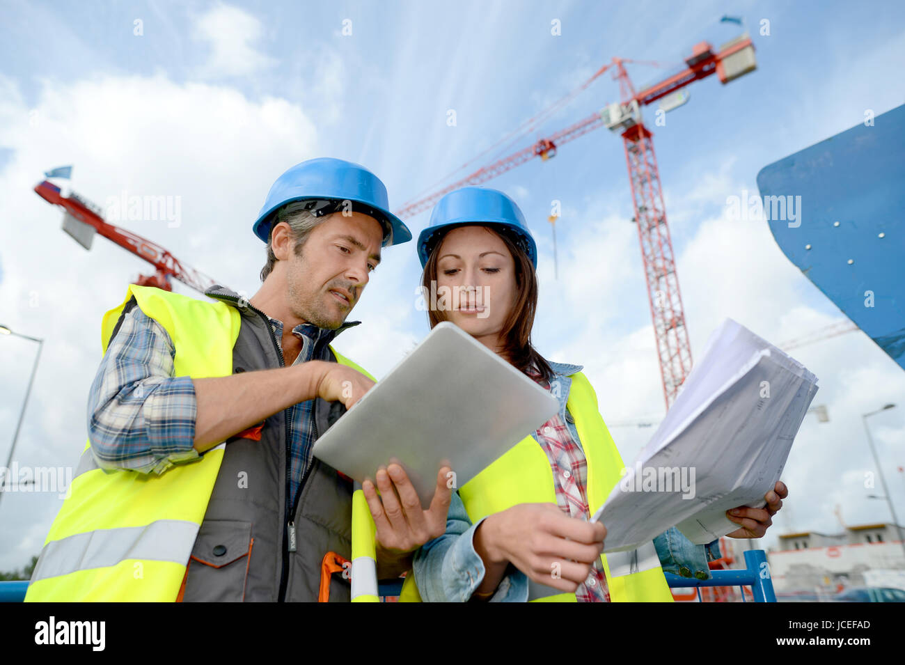 Construction manager and engineer working on building site Stock Photo ...