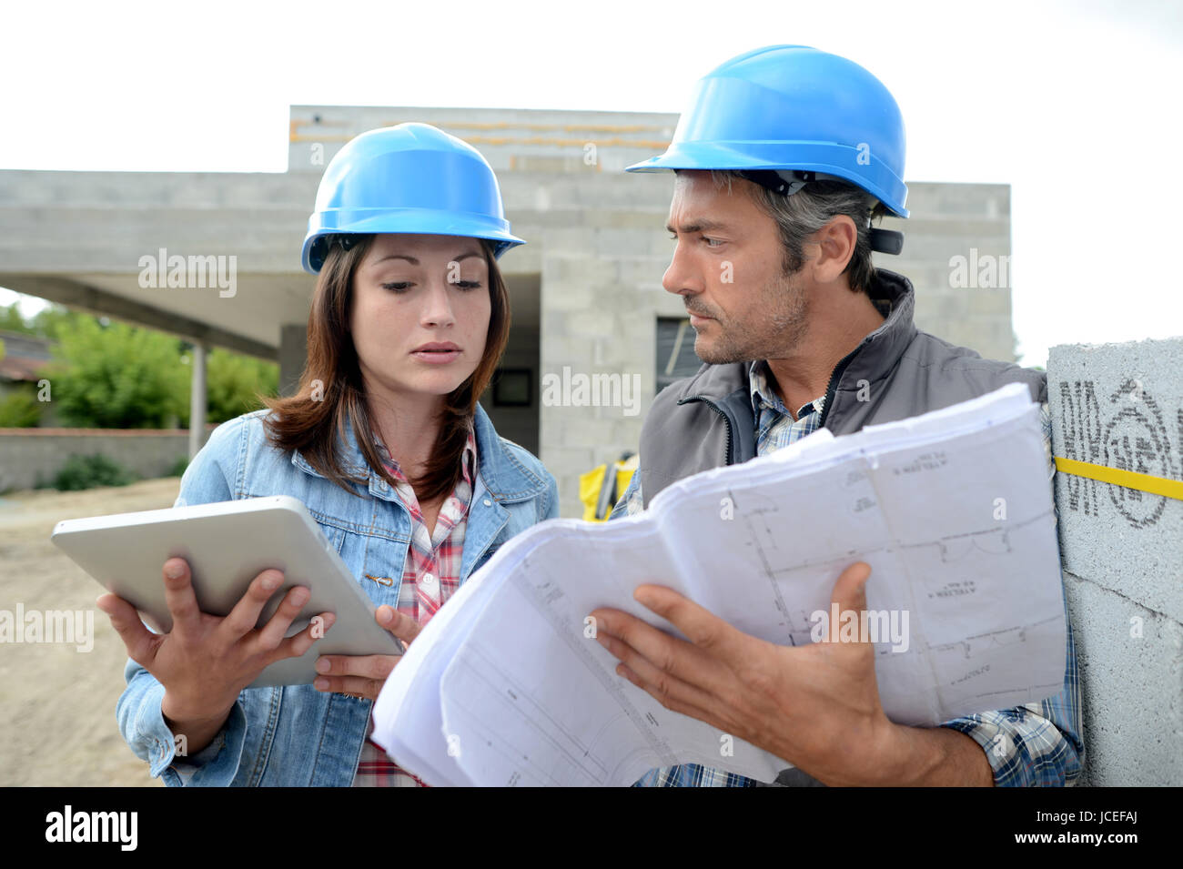 Construction team reading plan on site Stock Photo - Alamy