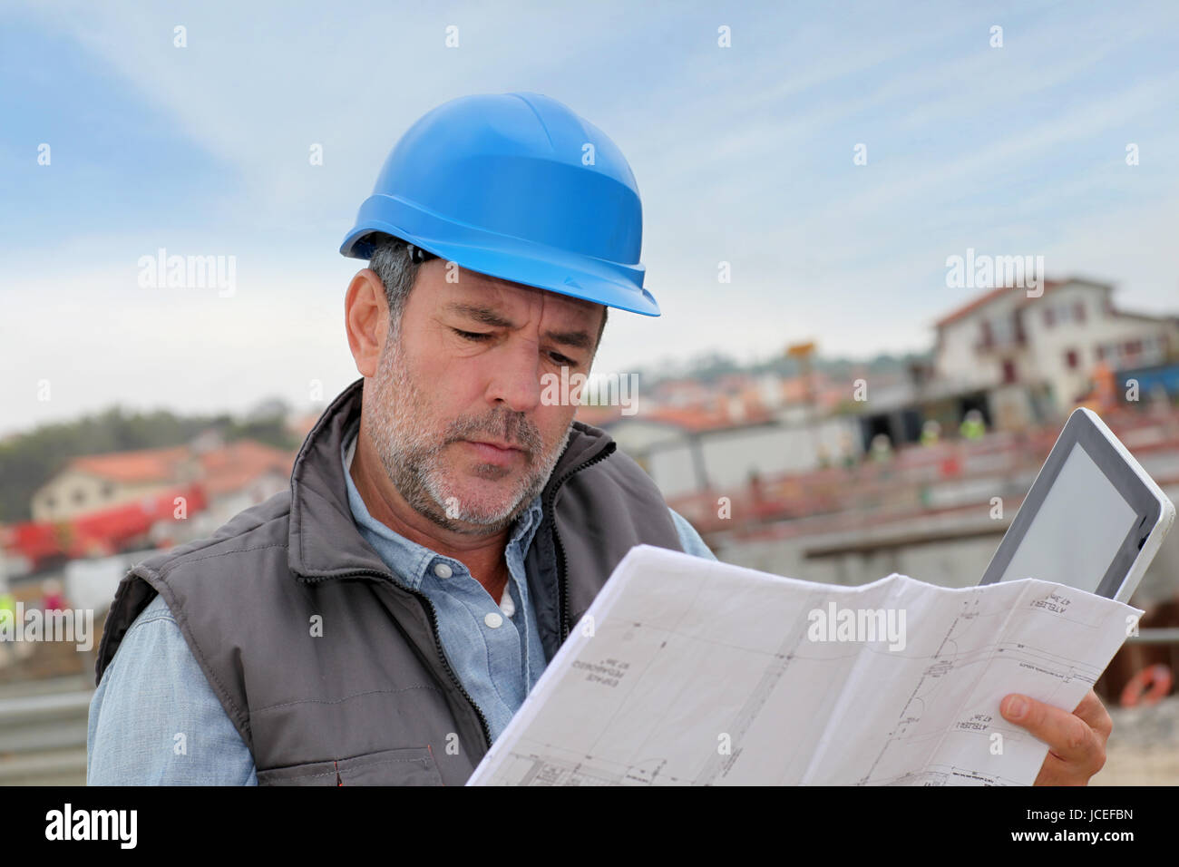 Construction manager controlling building site with plan Stock Photo ...