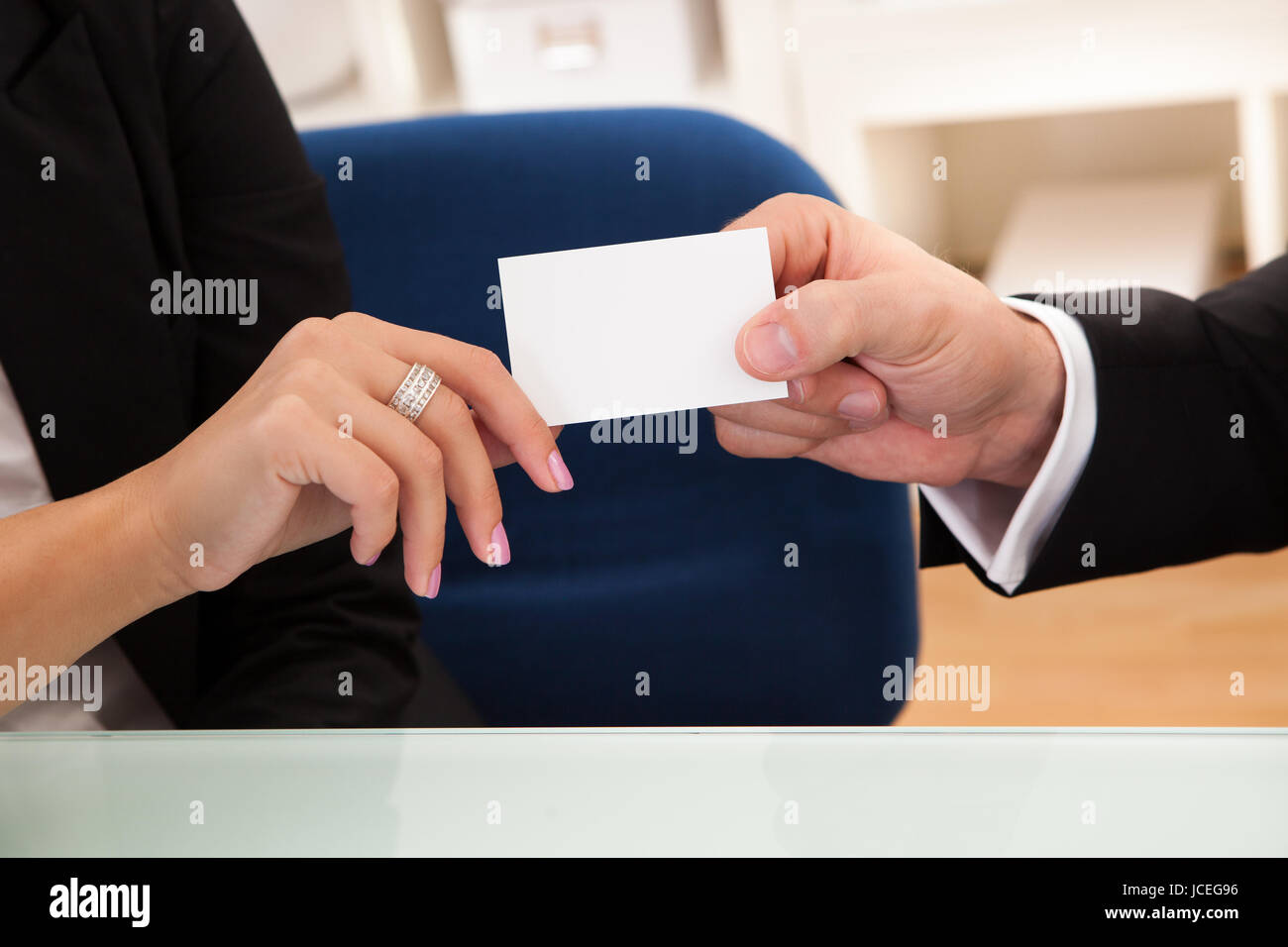 Cropped image of the hands of a business man handing over a blank white ...