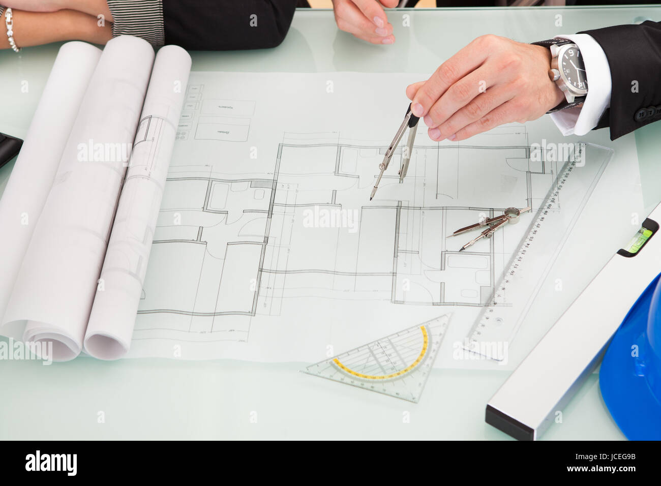 Cropped overhead view of a male and female architect discussing a set ...