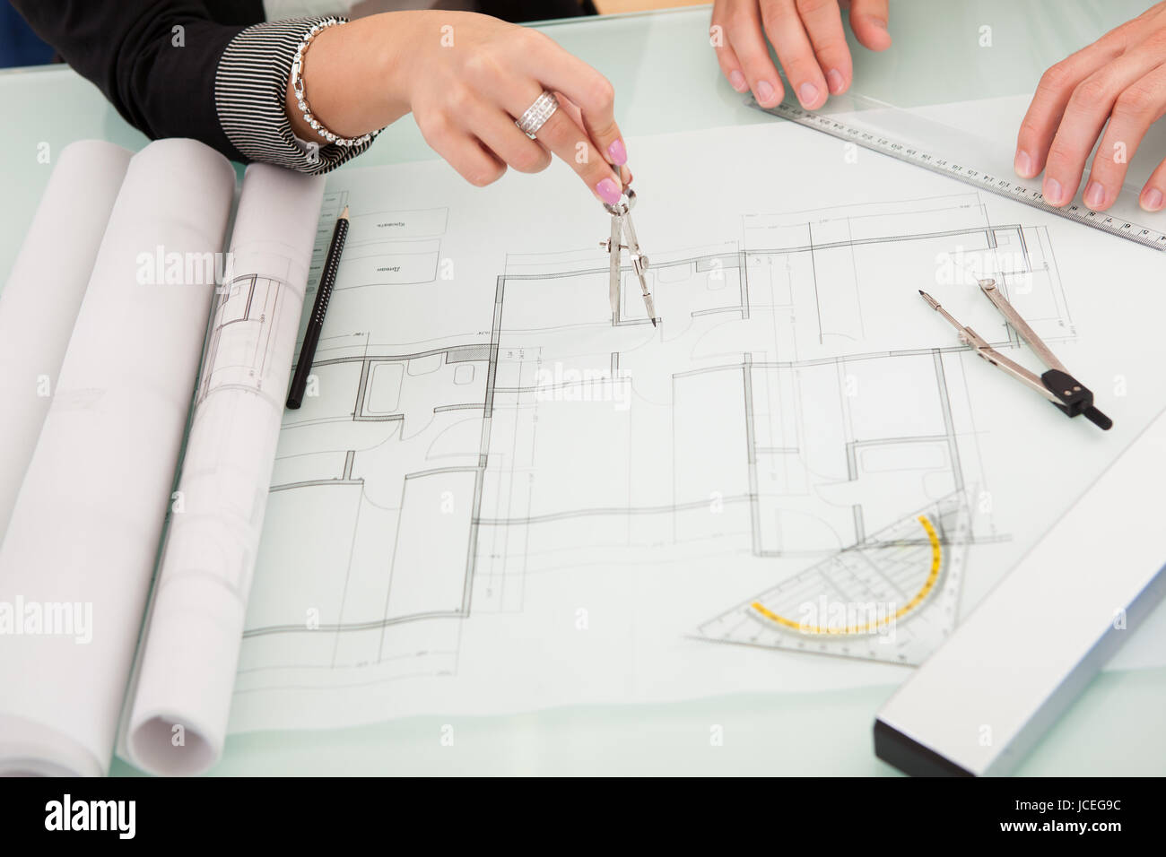 Cropped overhead view of a male and female architect discussing a set ...