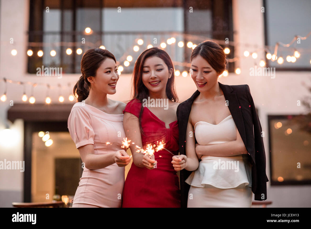 Smiling women with firecrackers at party Stock Photo - Alamy