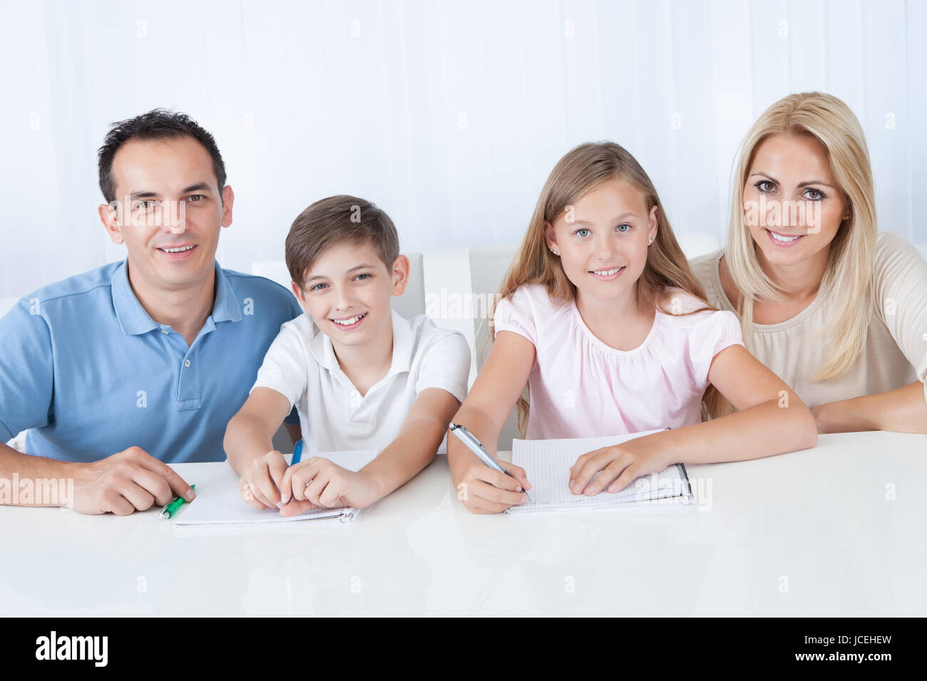 Parents Helping Their Children With Their Homework At Home Stock Photo ...