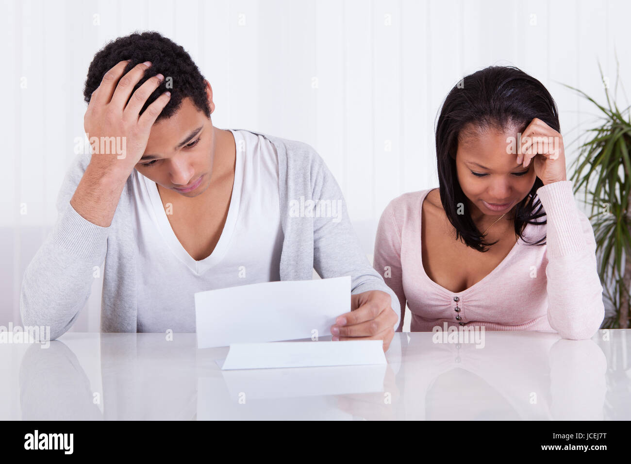 Portrait Of Worried Young Couple Looking At Paper Stock Photo - Alamy