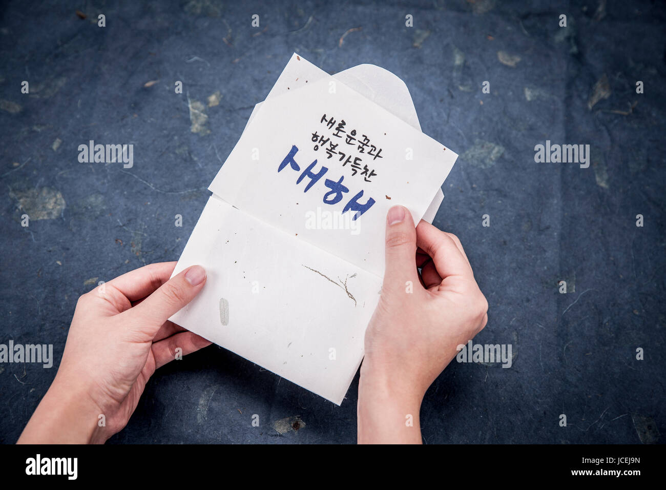 Hands with new year's greeting card Stock Photo - Alamy