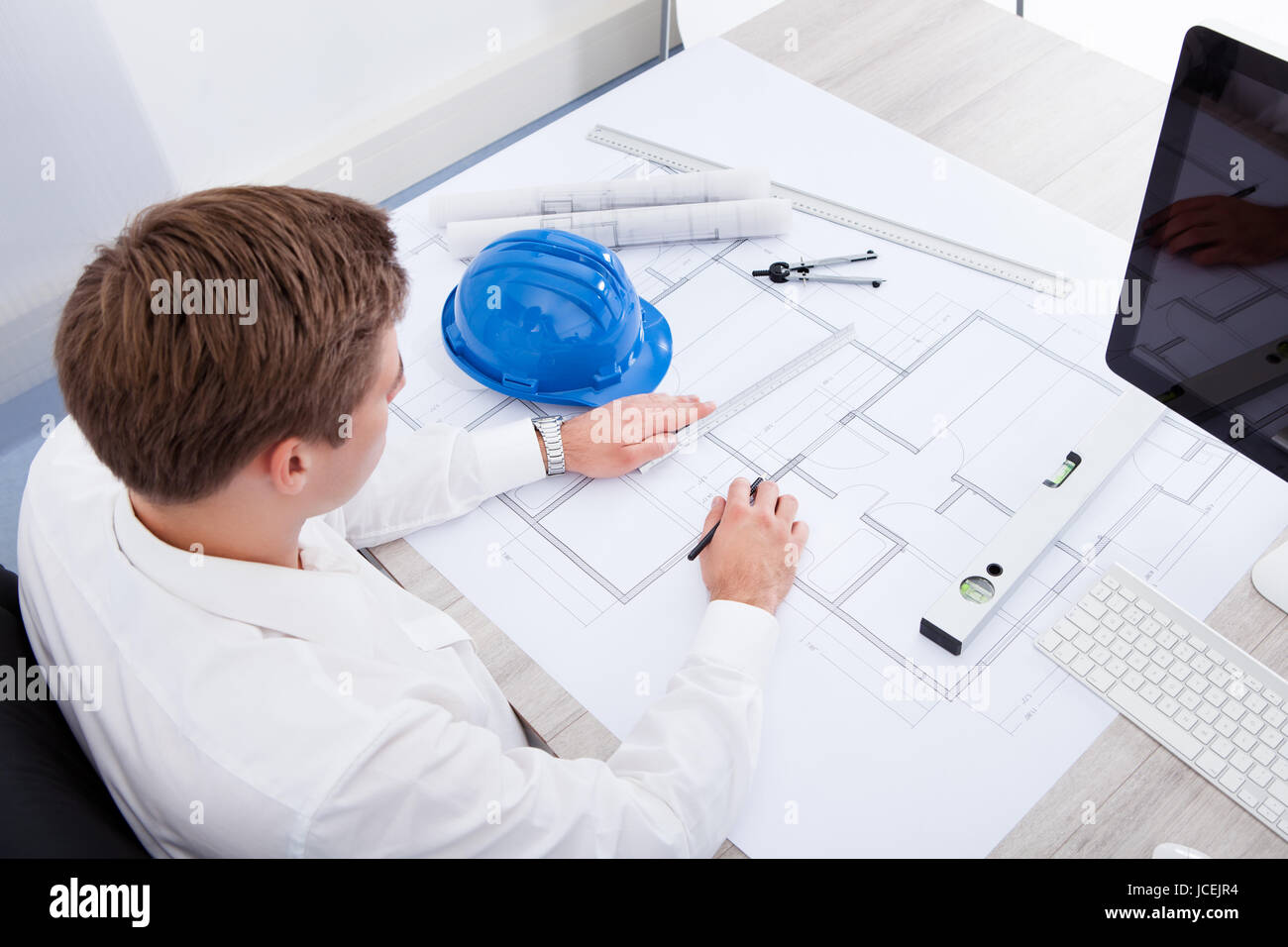 Portrait Of A Young Architect Drawing Plan On Blueprint Stock Photo - Alamy