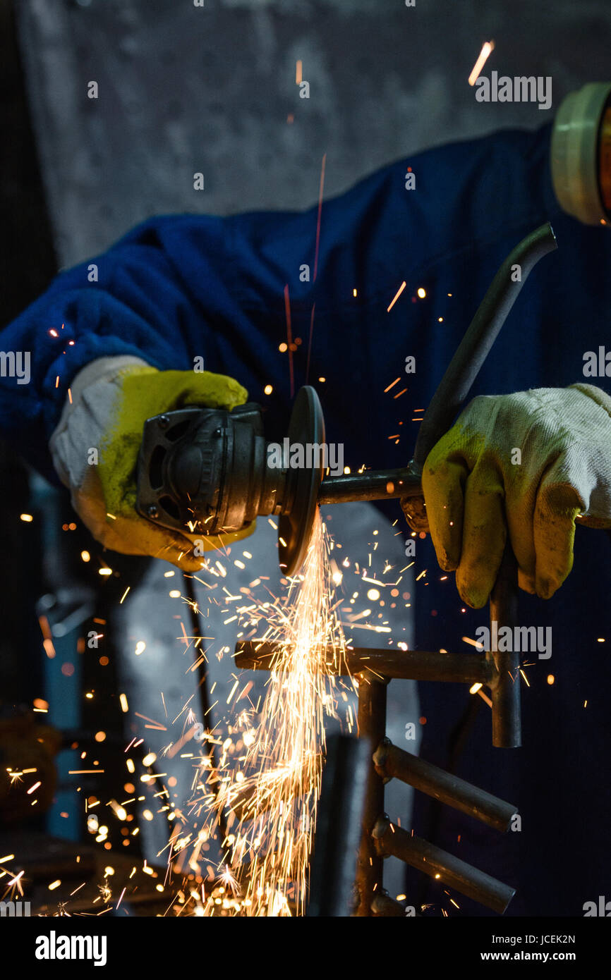 Metal grinding on steel pipe with flash of sparks close up Stock Photo ...