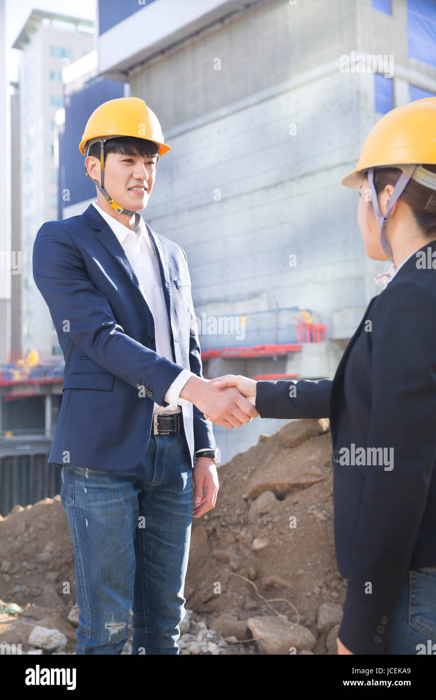 Two smiling architects making a handshake at construction site Stock ...