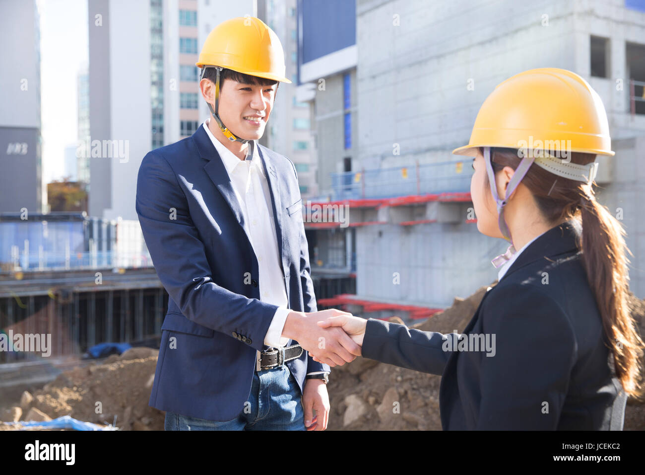 Smiling architects making a handshake at construction site Stock Photo ...