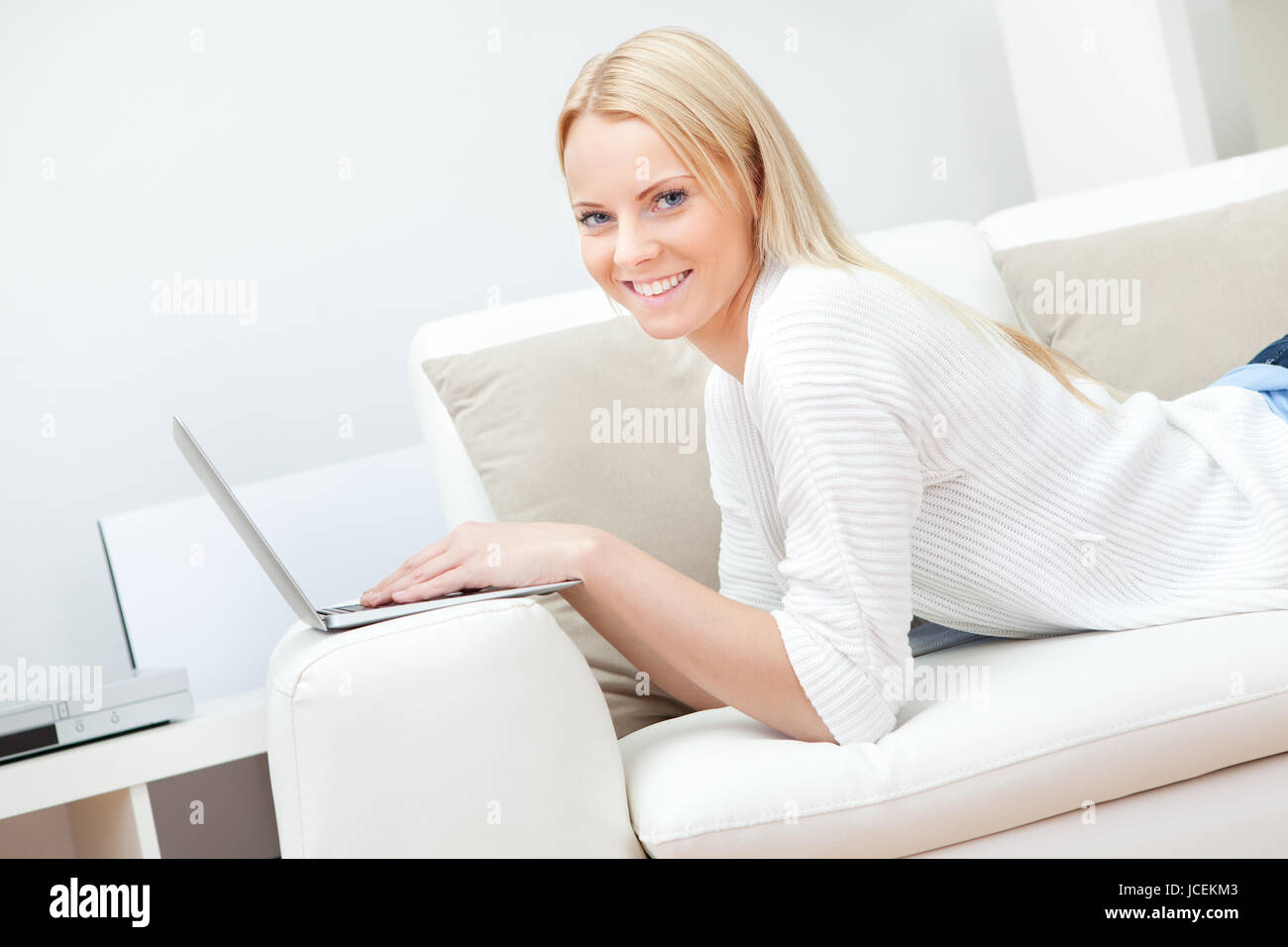 Beautiful woman working on computer sitting in sofa Stock Photo - Alamy