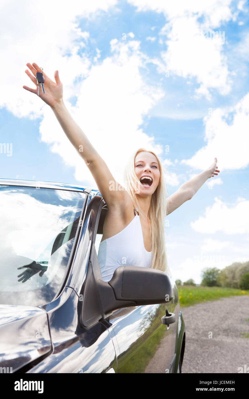 Happy Young Woman Raising Hand Out Of Car Window Stock Photo - Alamy