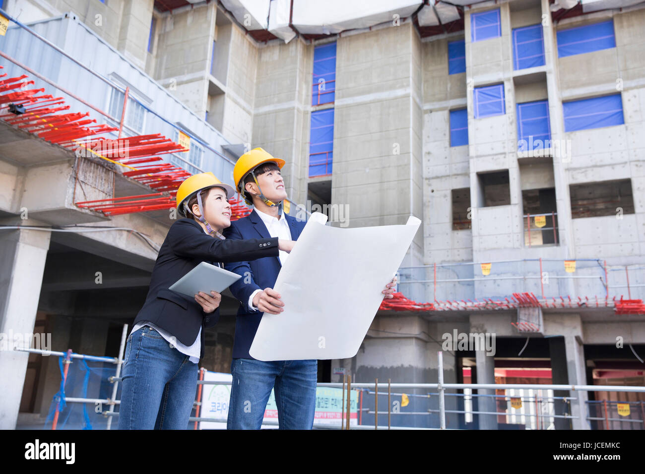 Two architects looking up at construction site Stock Photo - Alamy