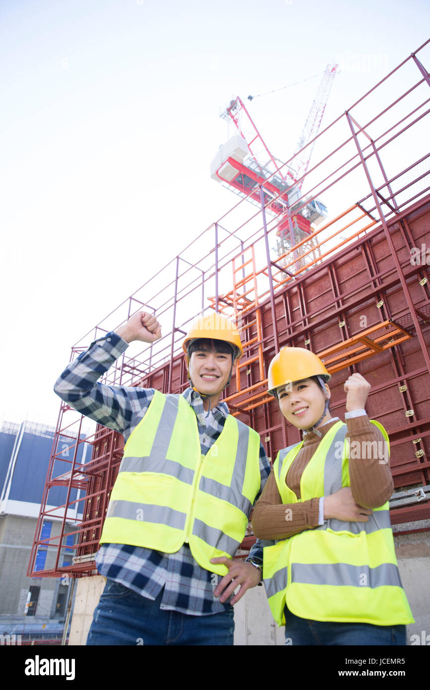 Smiling construction workers cheering Stock Photo - Alamy