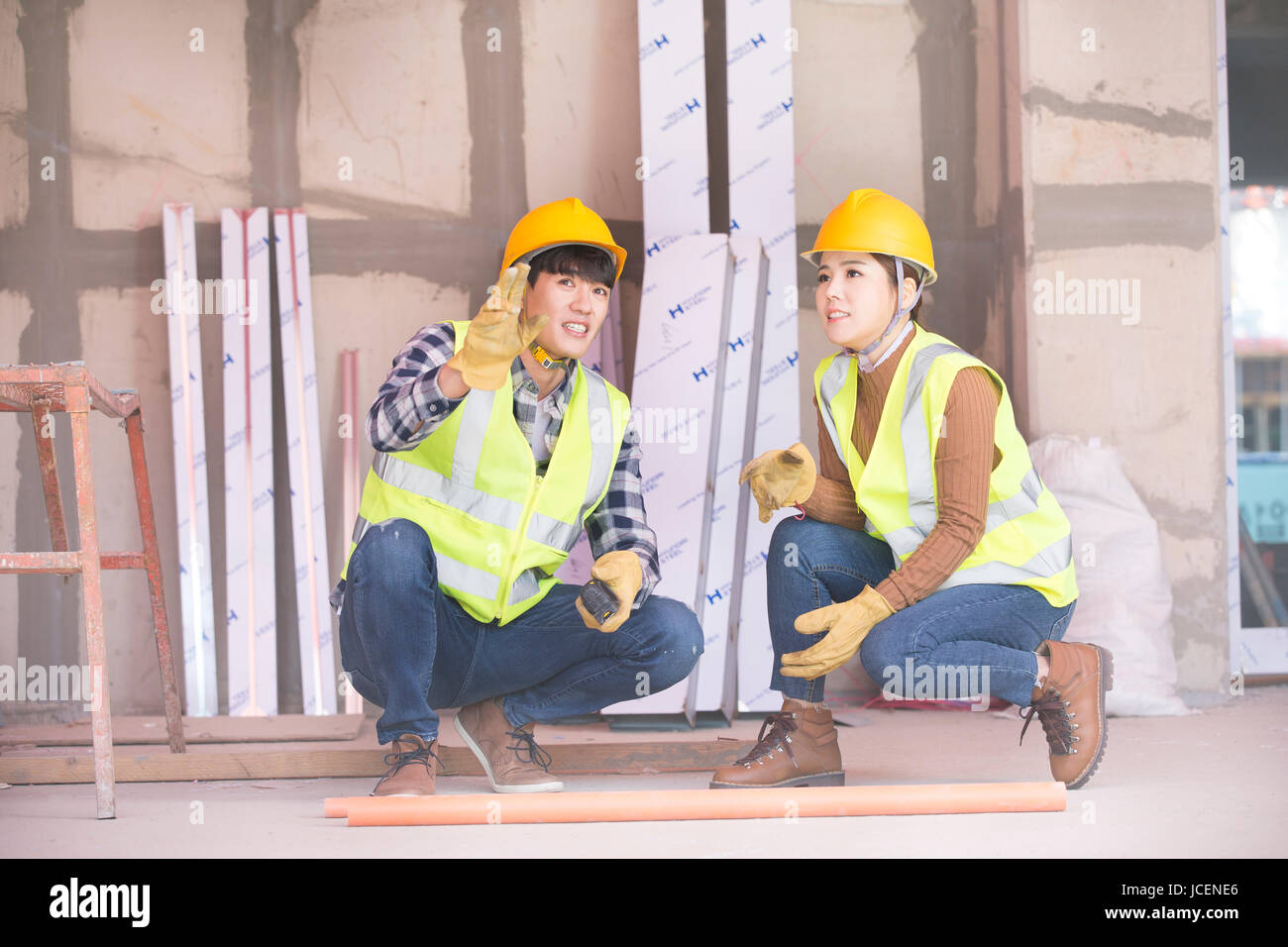 Construction workers squatting talking Stock Photo - Alamy