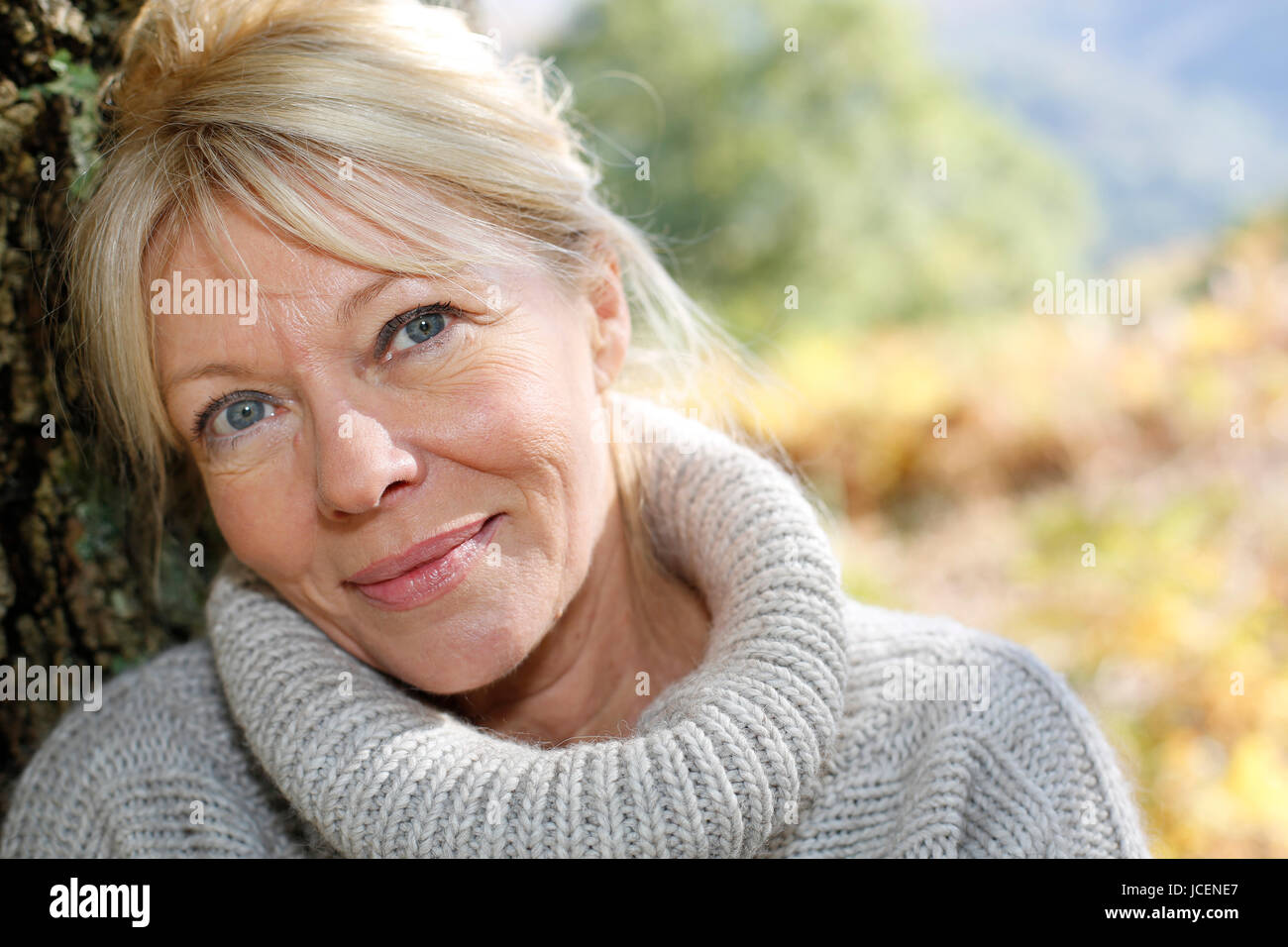 Senior woman leaning against tree hi-res stock photography and images ...