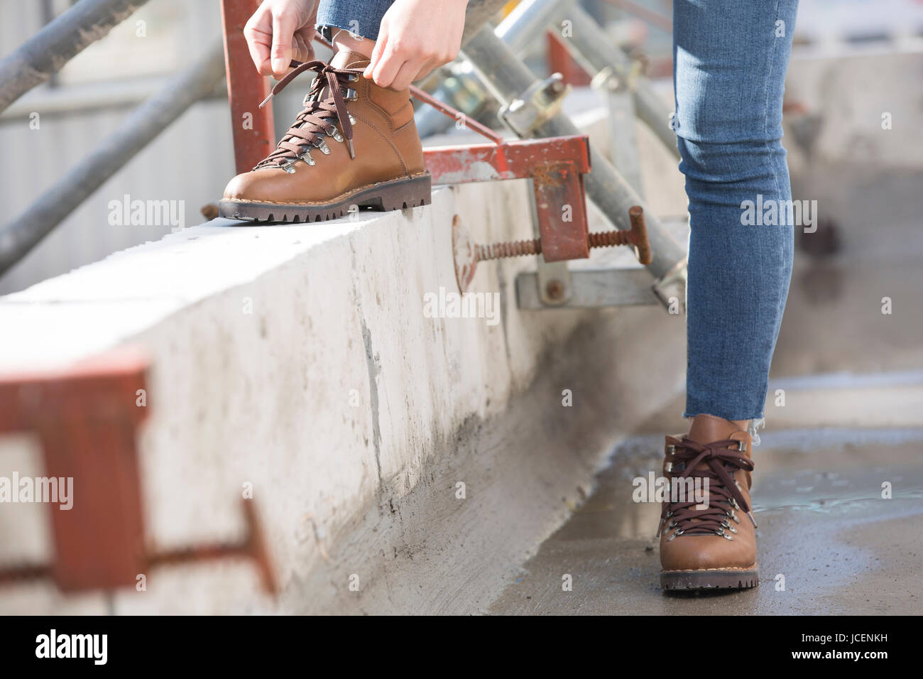 Construction worker tying shoestring Stock Photo - Alamy