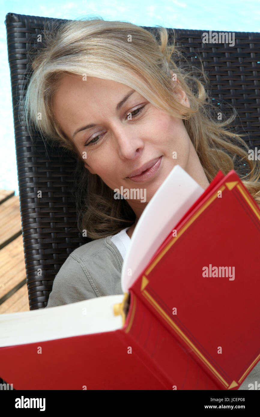 Portrait of woman reading book outside Stock Photo - Alamy