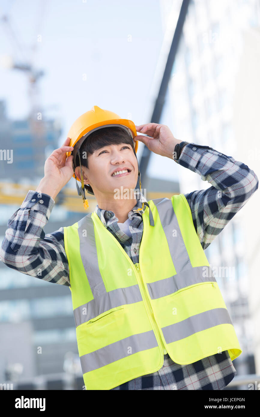 Young smiling construction worker Stock Photo - Alamy