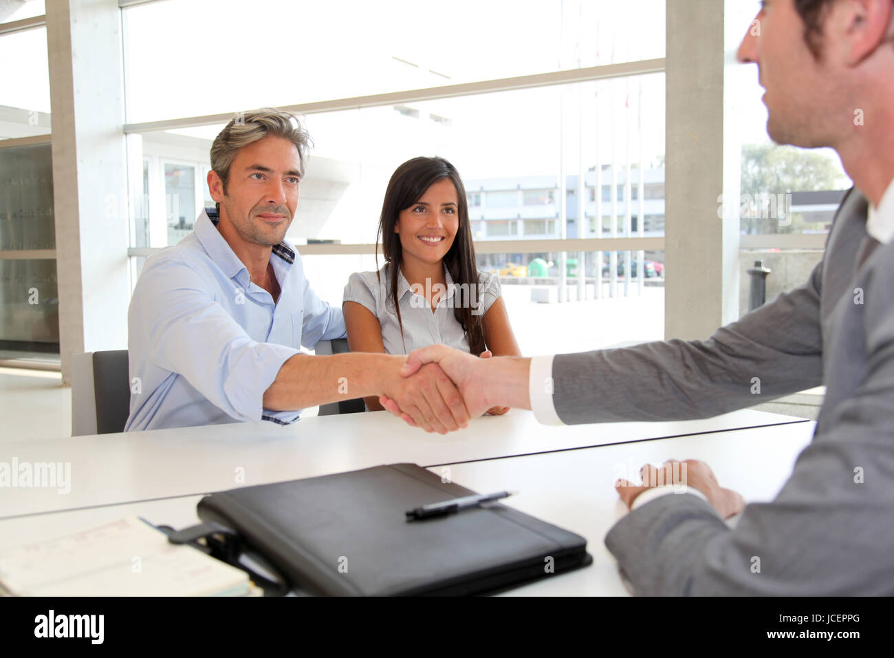 Man giving handshake to real-estate-agent Stock Photo - Alamy