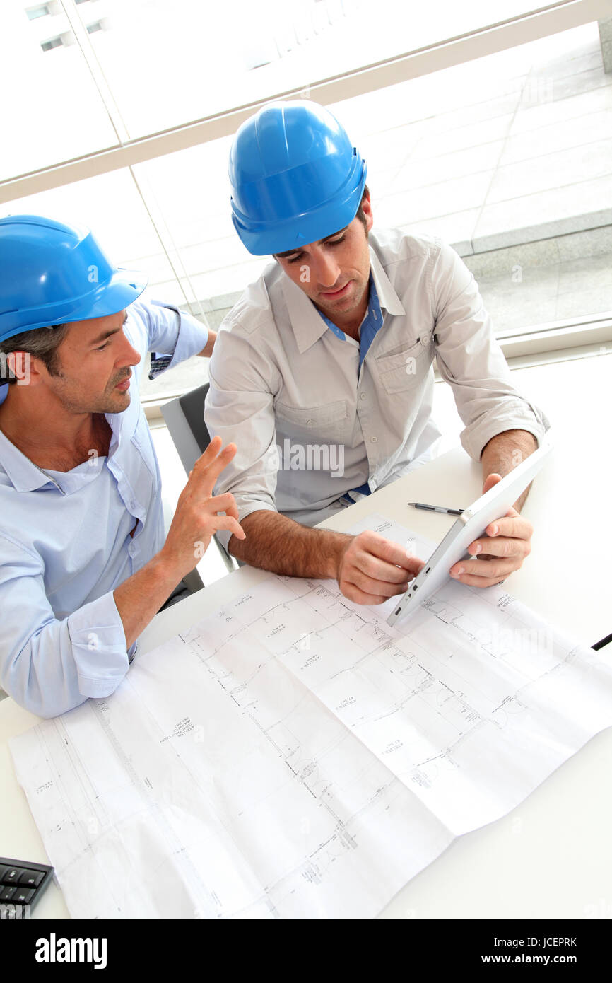 Architects working on construction plan Stock Photo - Alamy
