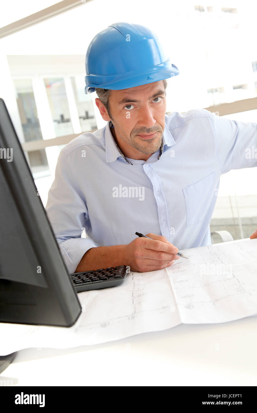 Engineer in office working on construction plan Stock Photo - Alamy