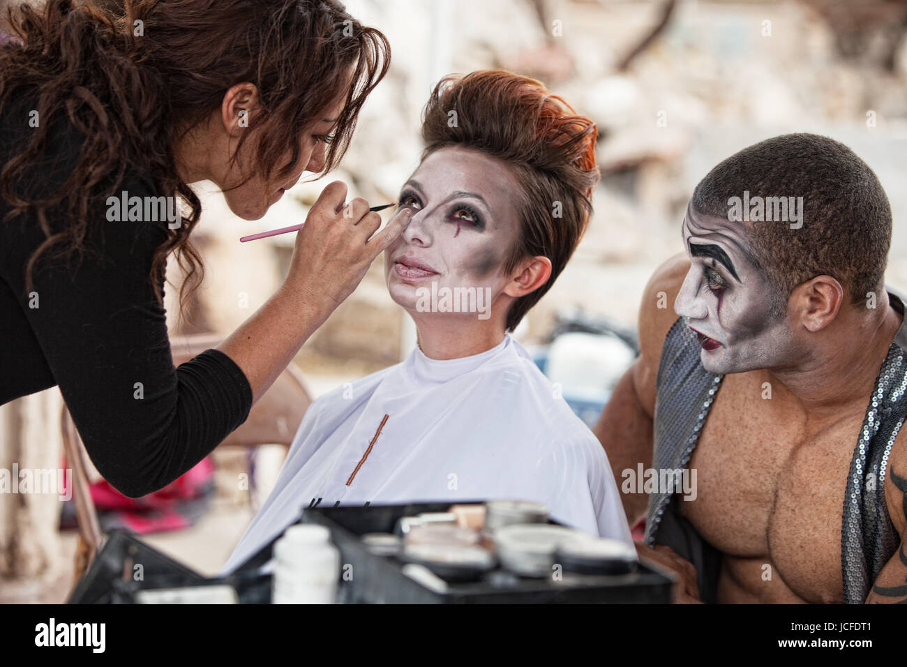 Male clown looking at woman getting makeup backstage Stock Photo - Alamy
