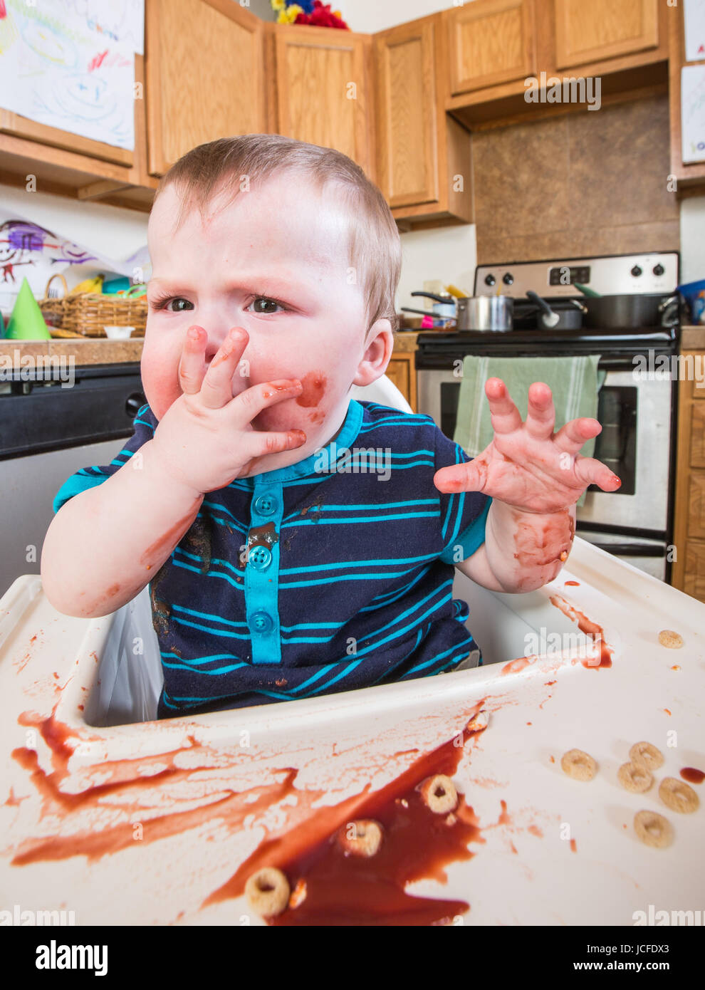 A grumpy child eats breakfast in the kitchen Stock Photo - Alamy