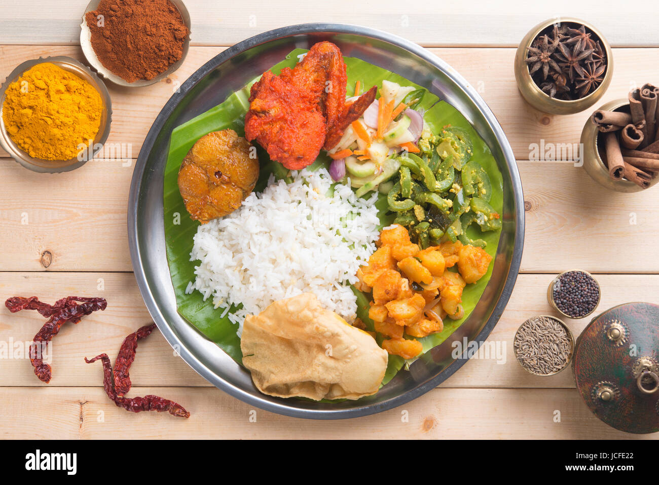 Overhead view of Indian mixed rice on wooden dining table with setting ...