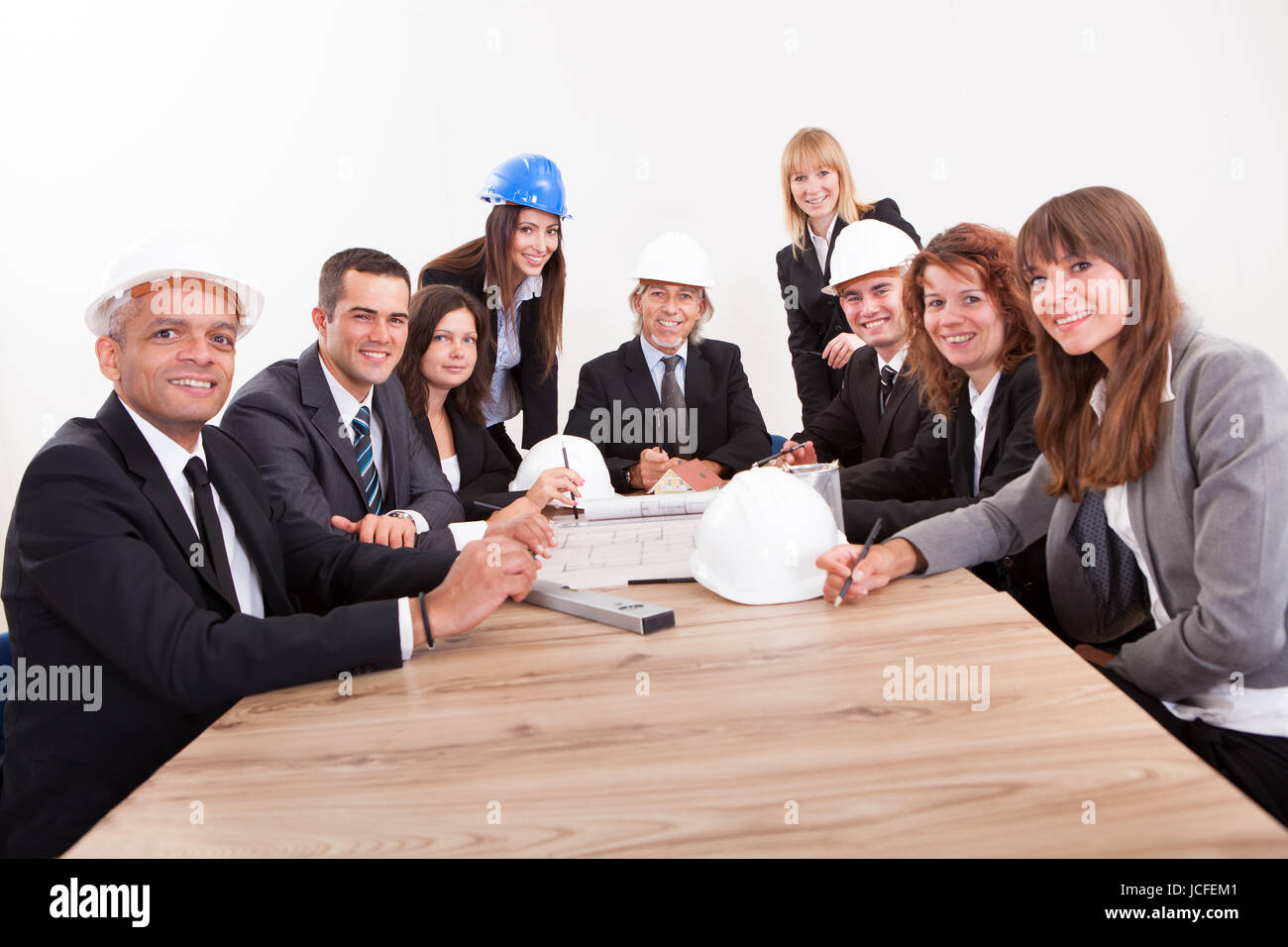 Engineers Discussing About A New Project Around A Table Pointing At A ...