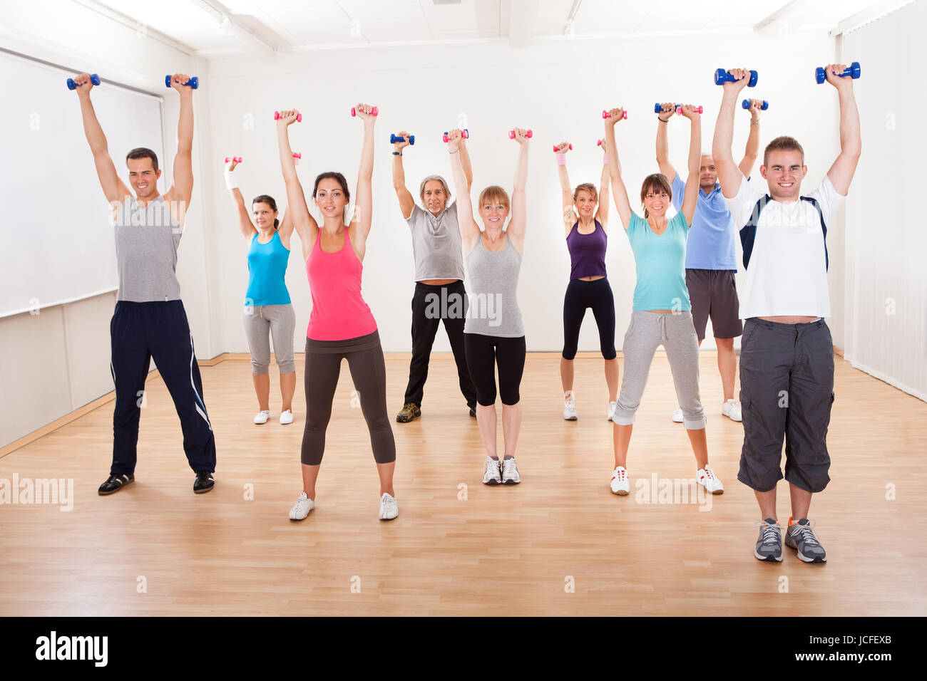 Aerobics class of diverse men and women of different ages working out ...
