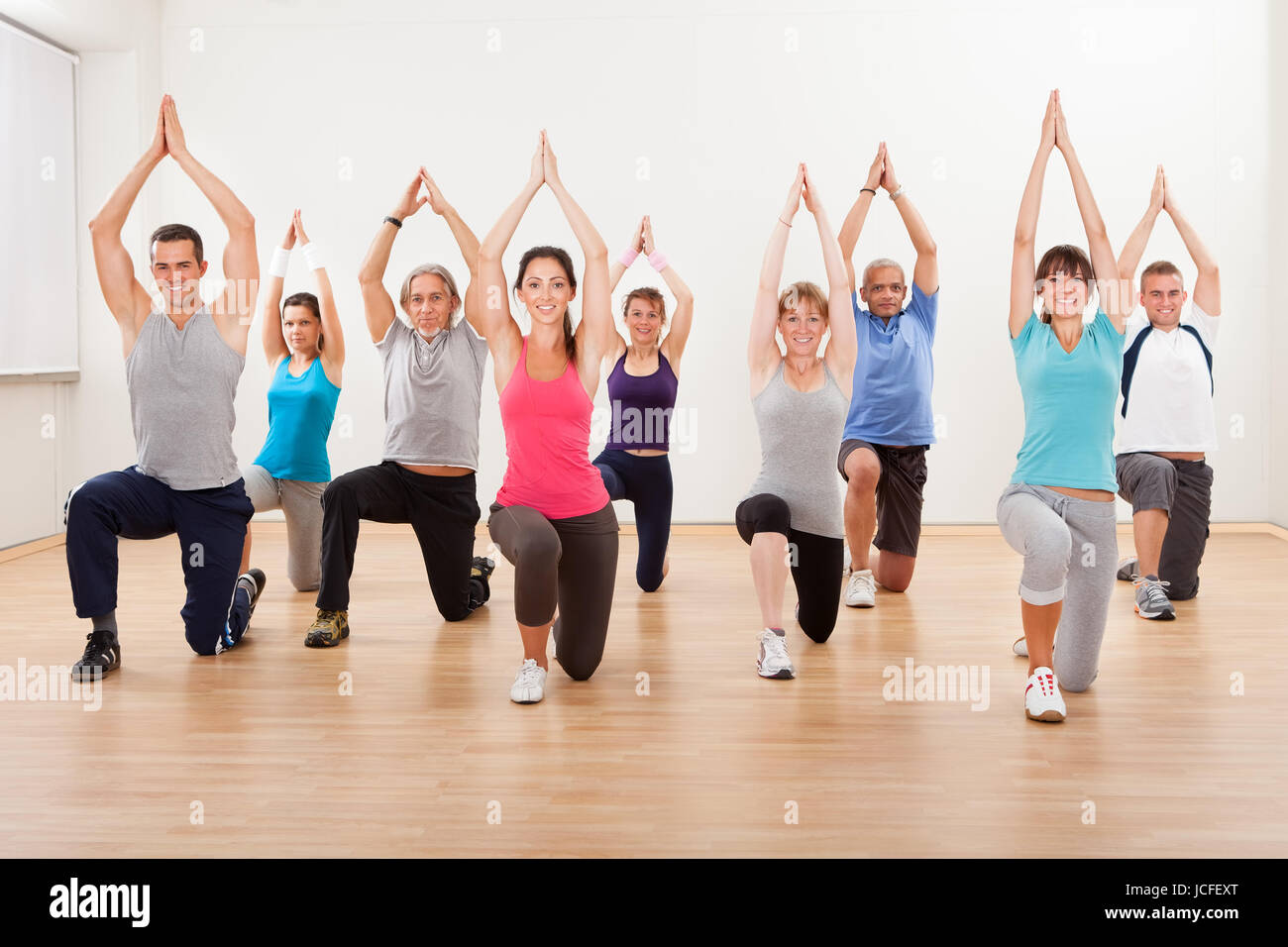 Large diverse group of people doing aerobics exercises in a class in a ...
