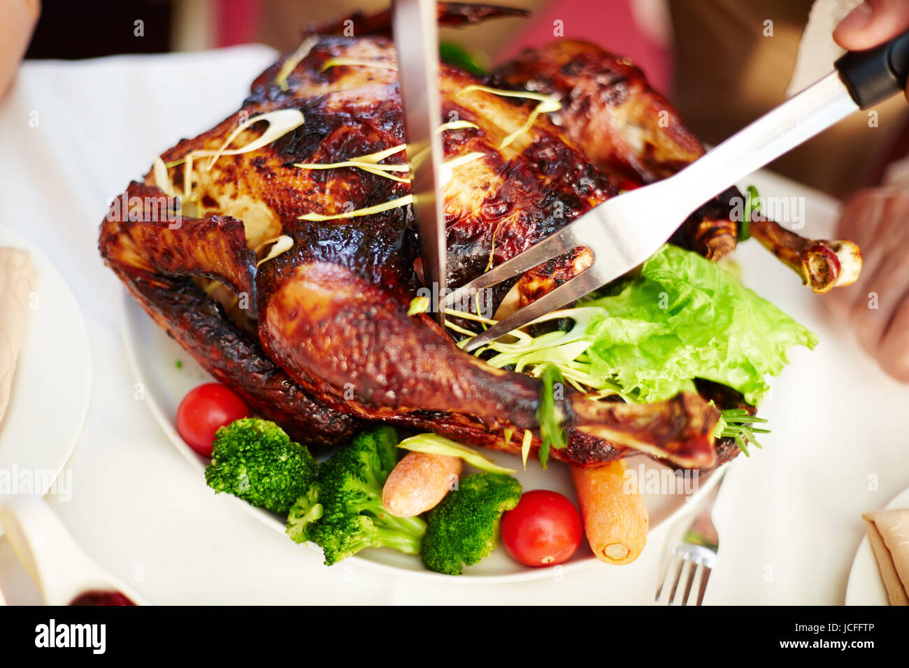 Tasty roasted turkey with vegetables being cut by a human Stock Photo ...