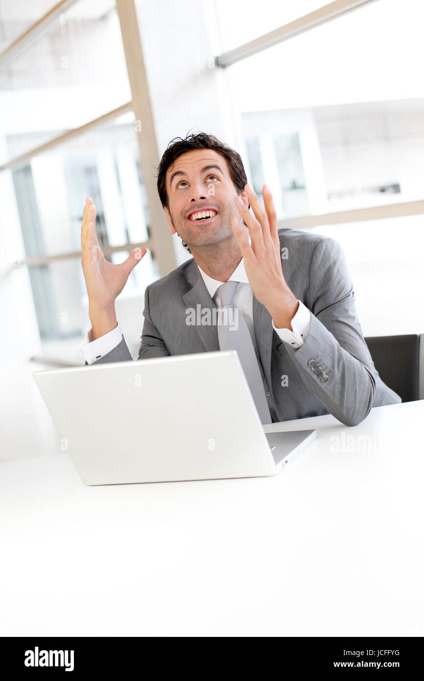 Portrait of businessman begging for good luck Stock Photo - Alamy