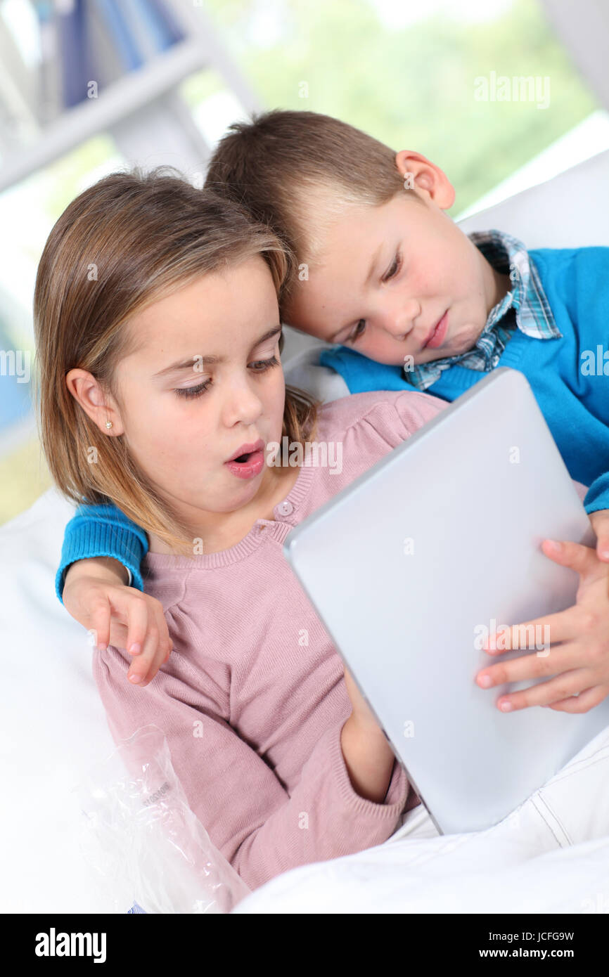 Children using electronic tablet at home Stock Photo - Alamy