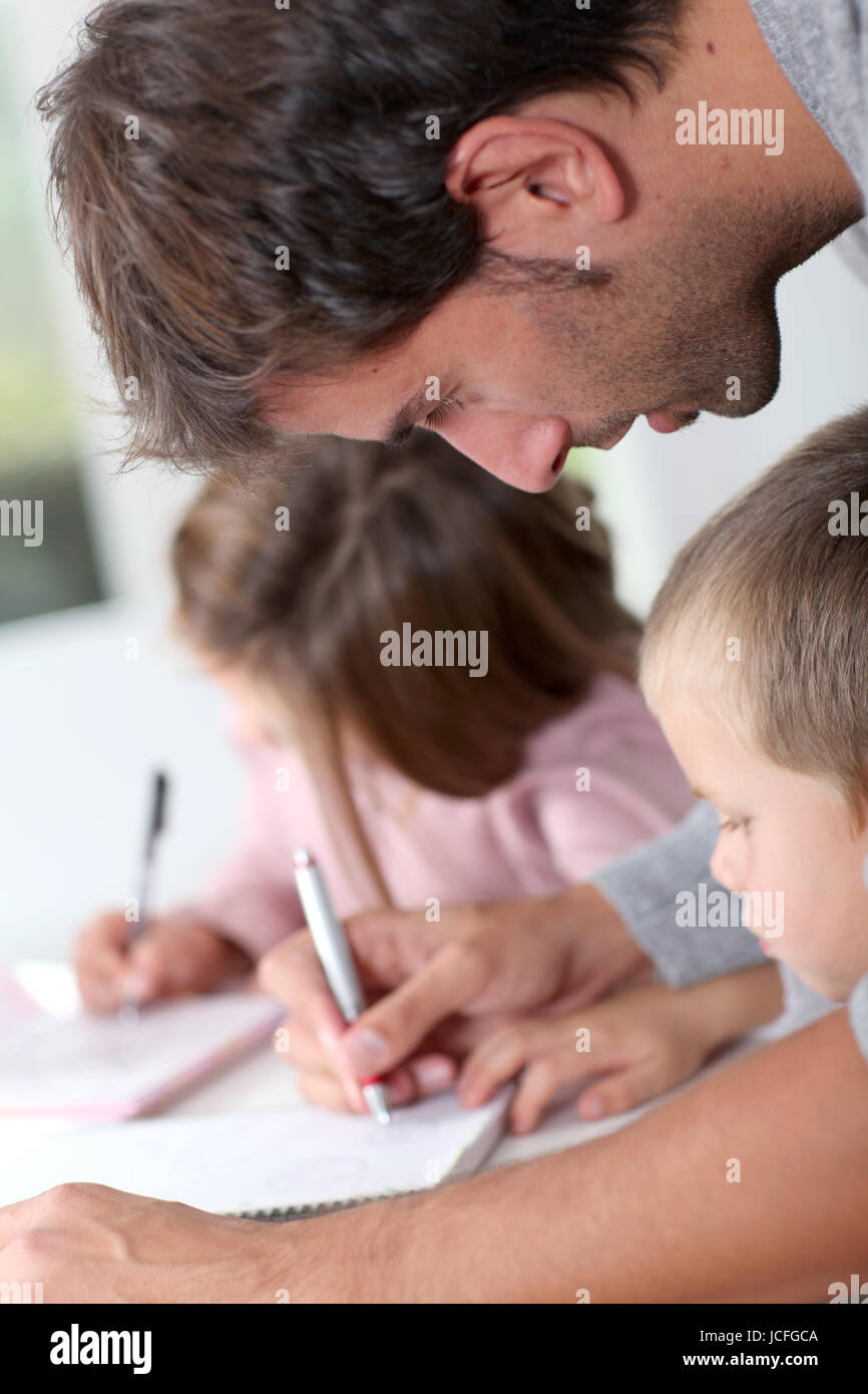 Man helping kids with homework Stock Photo - Alamy