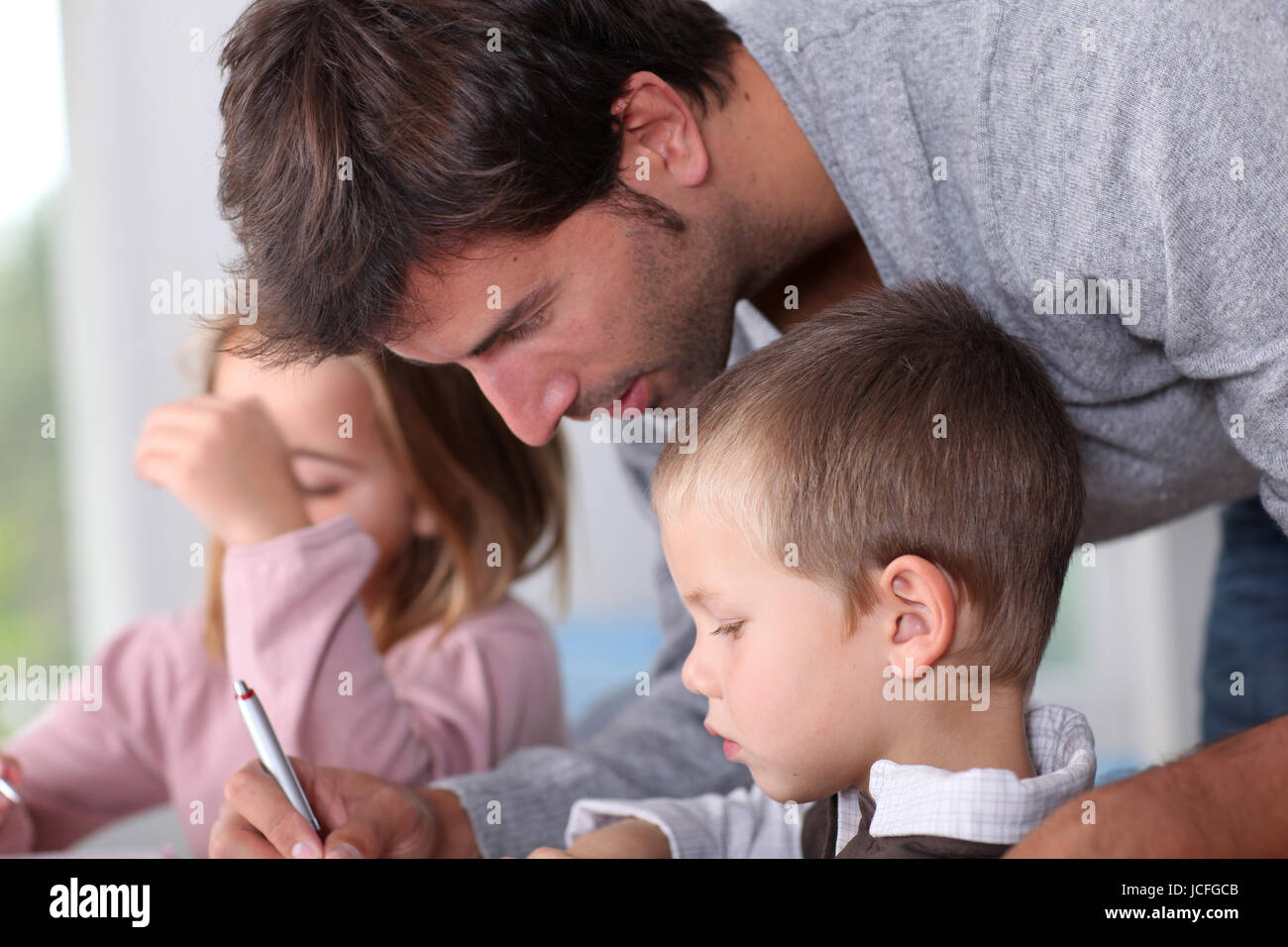 Man helping kids with homework Stock Photo - Alamy