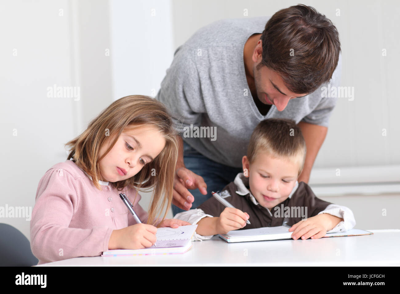 Man helping kids with homework Stock Photo - Alamy