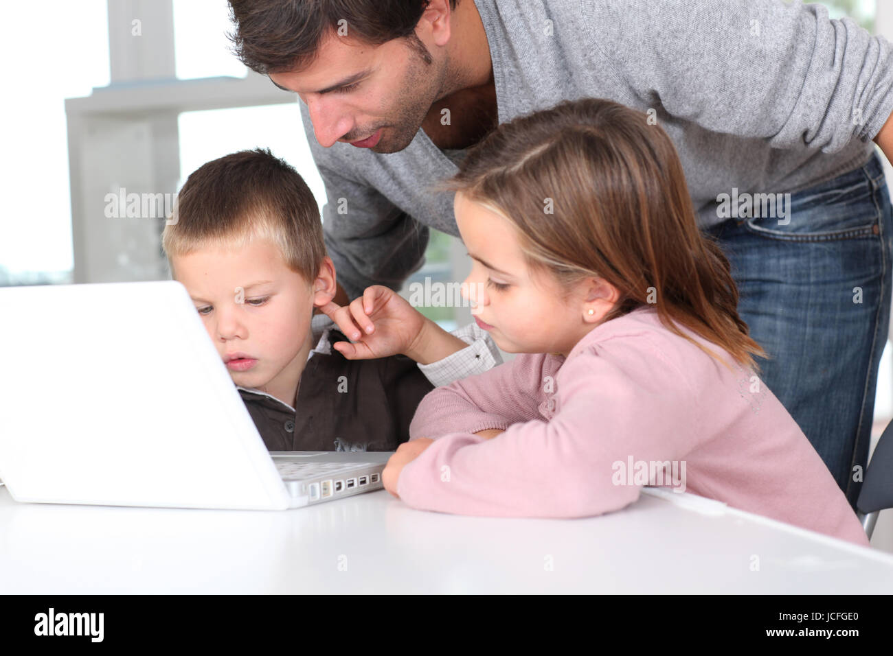 Man teaching kids how to use laptop computer Stock Photo - Alamy