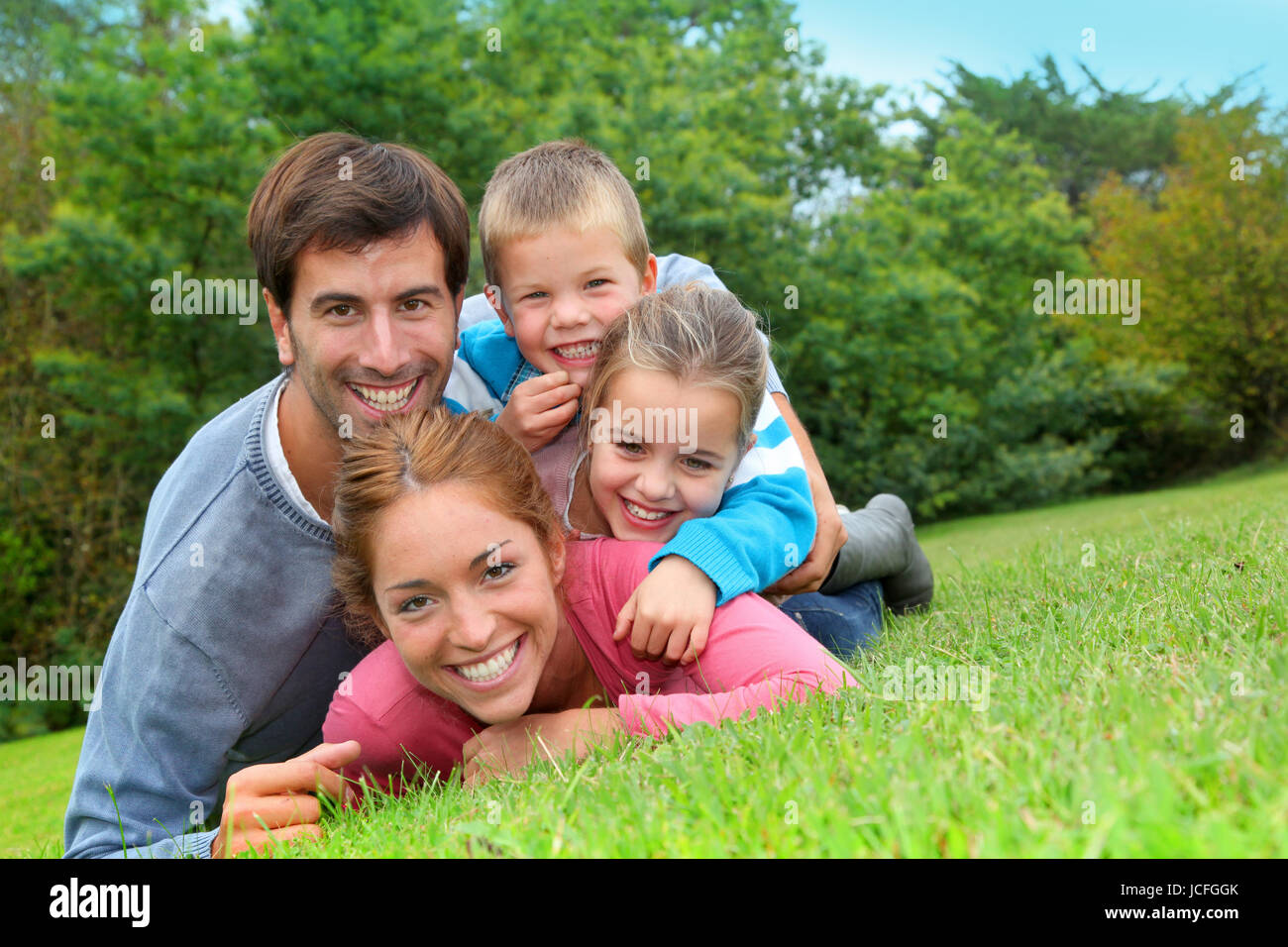 Portrait of happy family laying in country field Stock Photo - Alamy
