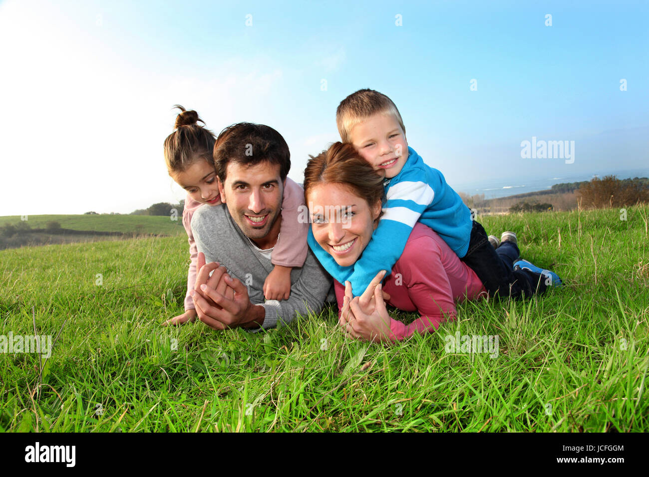 Portrait of happy family laying in country field Stock Photo - Alamy