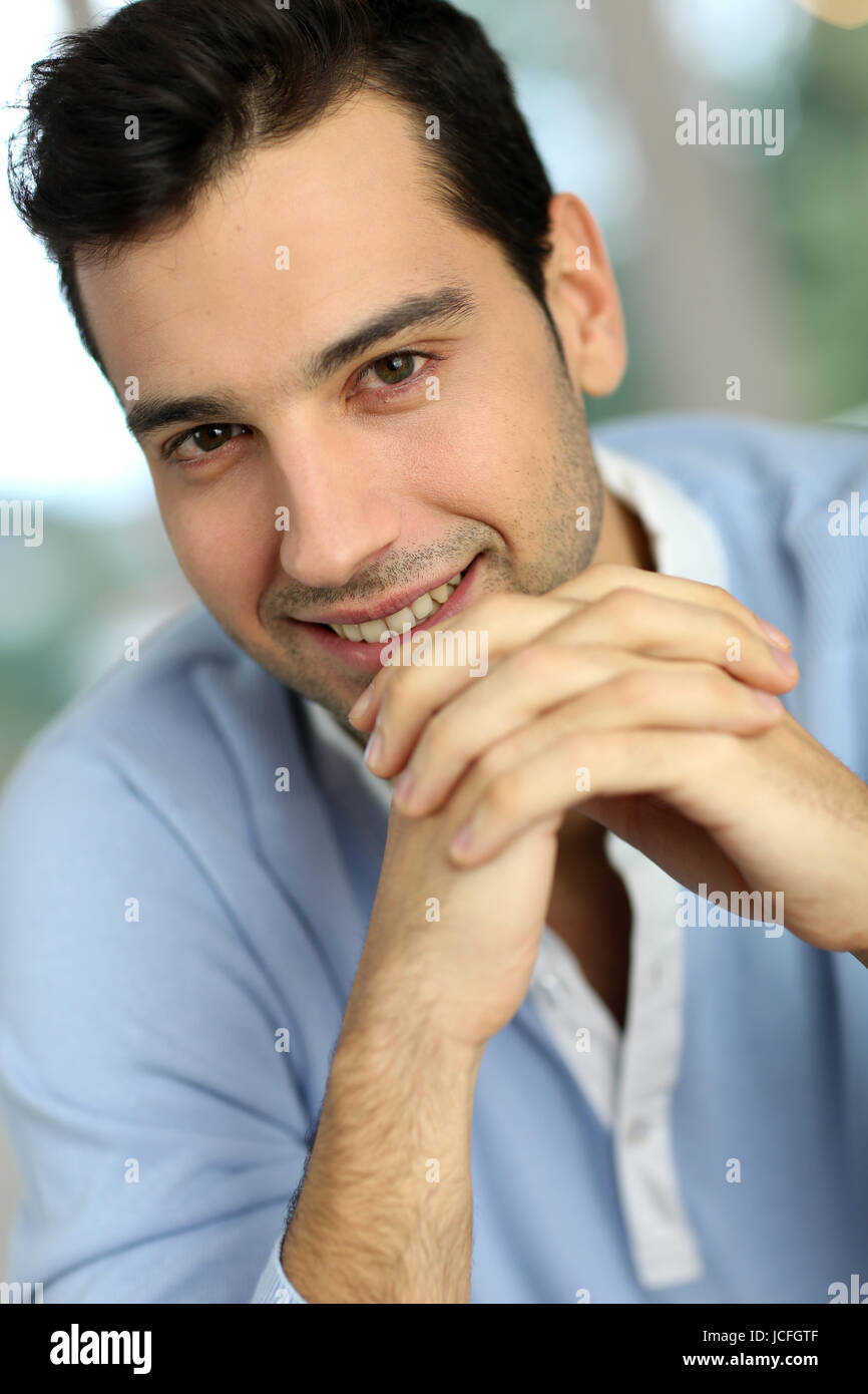 Portrait of young man with hand on chin Stock Photo - Alamy