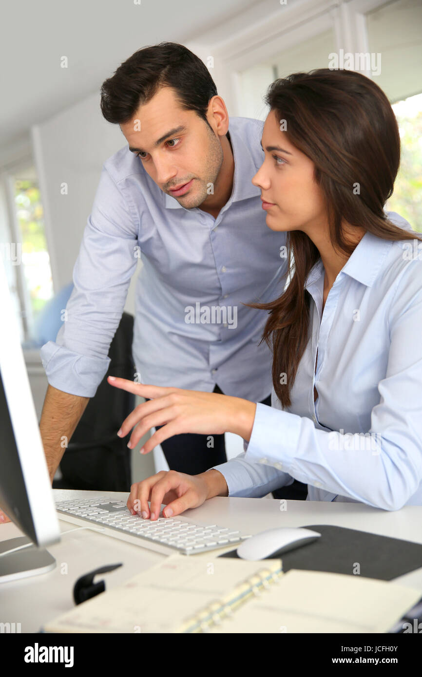 Young office workers in front of desktop computer Stock Photo - Alamy