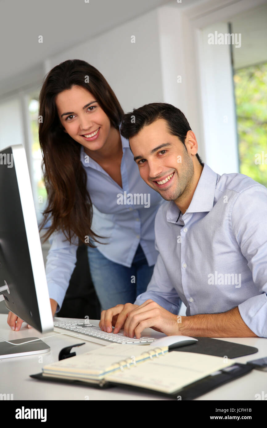 Young office workers in front of desktop computer Stock Photo - Alamy