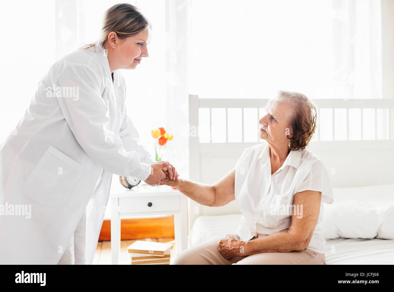 Providing care and support for elderly. Doctor visiting elderly patient ...