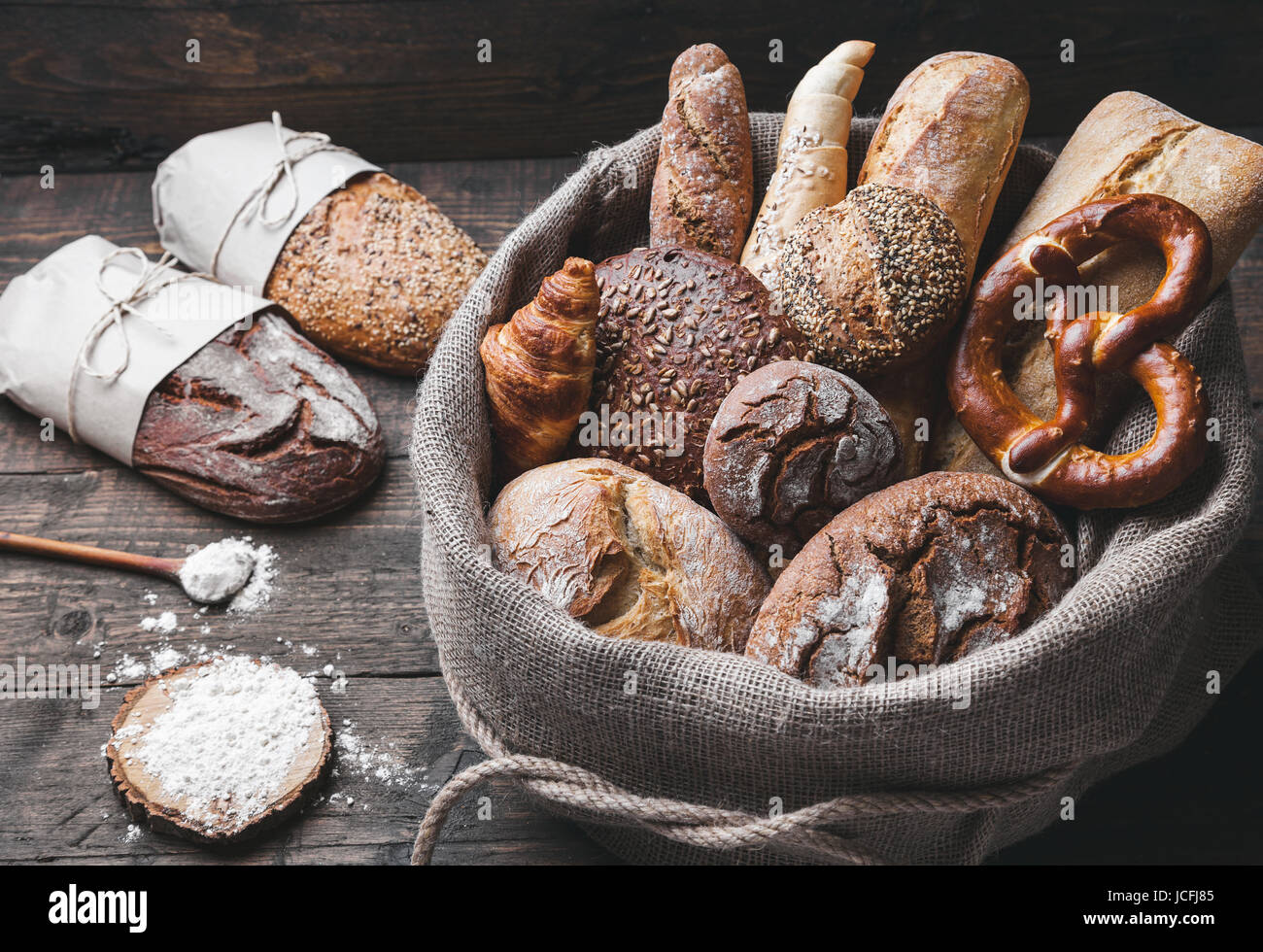 Delicious freshly baked bread inside a sack on wooden background Stock ...
