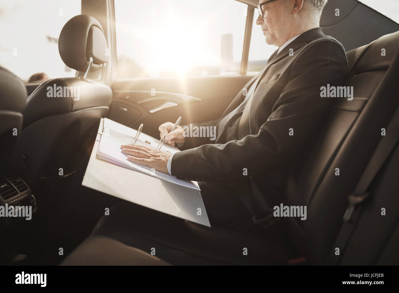 senior businessman with papers driving in car Stock Photo - Alamy