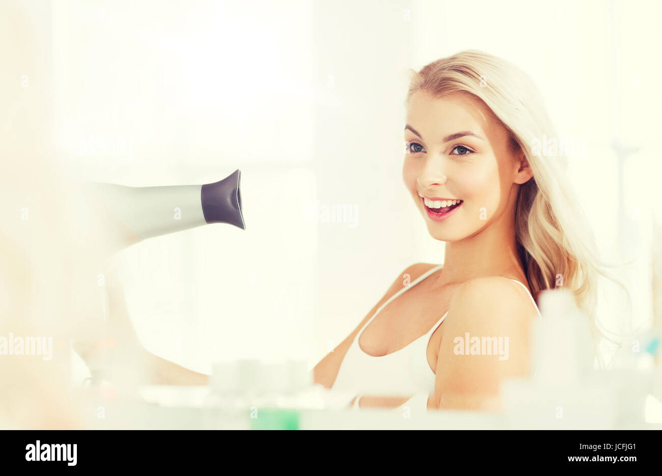 happy young woman with fan drying hair at bathroom Stock Photo - Alamy