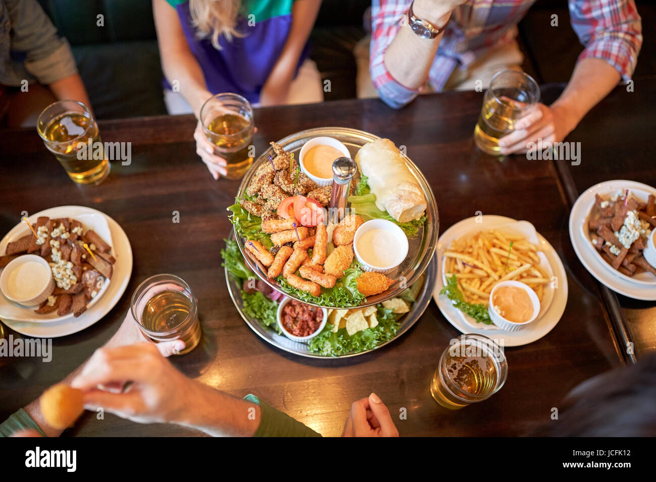 friends eating and drinking at bar or pub Stock Photo - Alamy