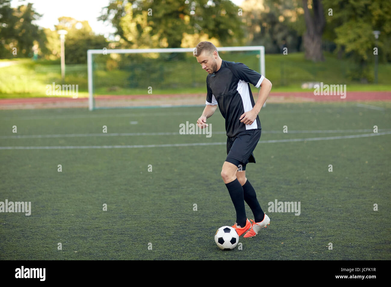 soccer player playing with ball on football field Stock Photo - Alamy